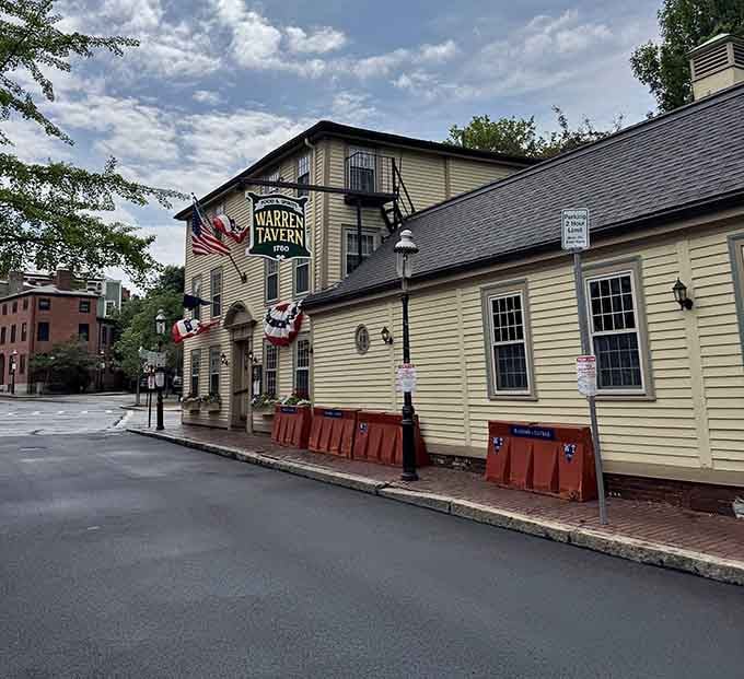 The yellow clapboard exterior of Warren Tavern stands as a colonial time capsule, complete with patriotic bunting and a welcoming patio for history buffs and foodies alike.