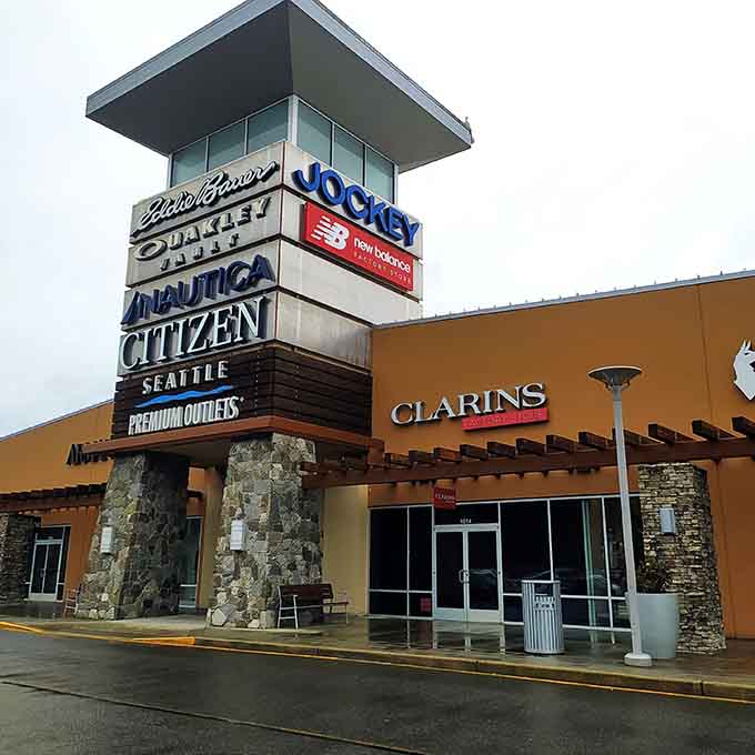 The outlet's entrance tower stands like a fashionable lighthouse, guiding bargain hunters to shores of discounted Eddie Bauer, New Balance, and Nautica treasures.