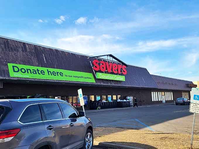 The iconic red Savers sign beckons like a lighthouse to thrift enthusiasts, promising treasures within this unassuming building where one person's castoffs become another's discoveries.