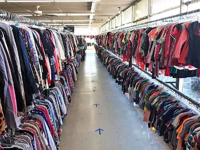 The clothing aisles at City Thrift create a canyon of color where patience and persistence lead to fashion gold at fraction-of-retail prices.