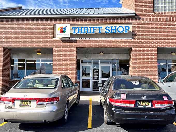 Blue letters promising adventure! The thrift shop sign beckons like a retail oasis, where your next vintage find is just waiting to be discovered.
