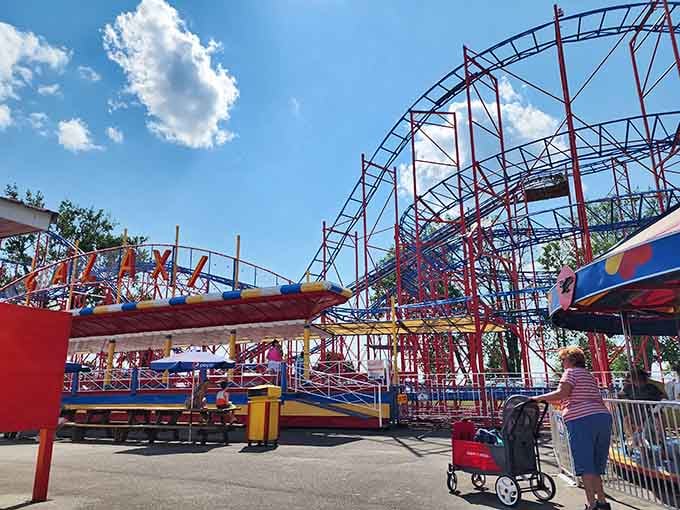 The iconic red and blue roller coaster stands against a perfect summer sky, promising the kind of old-school thrills money usually can't buy anymore.