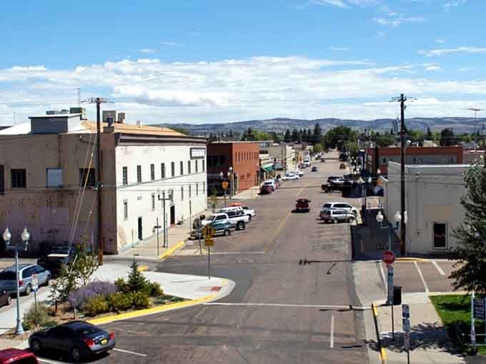 Wide open streets and mountain views frame this peaceful Wyoming town, where blue skies stretch endlessly above historic buildings.