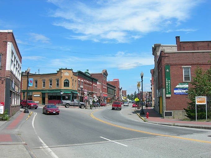 Skowhegan's vibrant downtown showcases historic brick buildings under bright blue skies, offering affordable small-town charm with modern amenities.