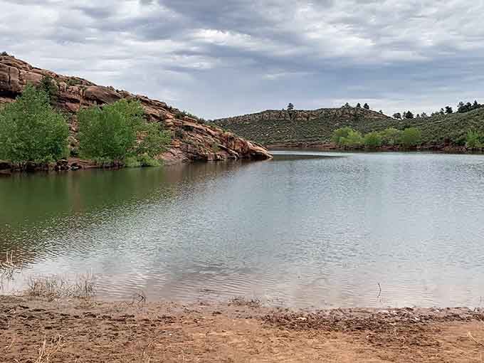 Red rock formations embrace the tranquil waters of Horsetooth Reservoir, creating perfect coves for paddlers exploring Lory's shoreline.