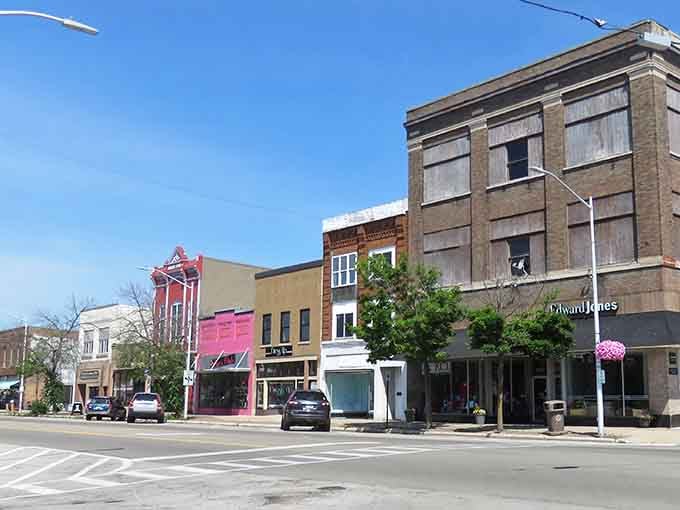 Colorful historic buildings line this sunny small-town street, where hanging flower baskets add a touch of beauty to the quiet afternoon.
