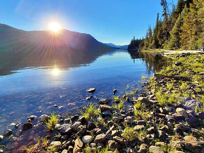 Sunrise magic at its finest! The morning light creates a double sun effect as it bounces off Lake Wenatchee's crystal-clear waters, nature's own light show.