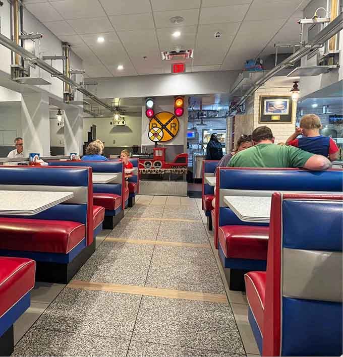 Red and blue booths are packed with happy customers as the overhead railway brings their meals straight to the table.
