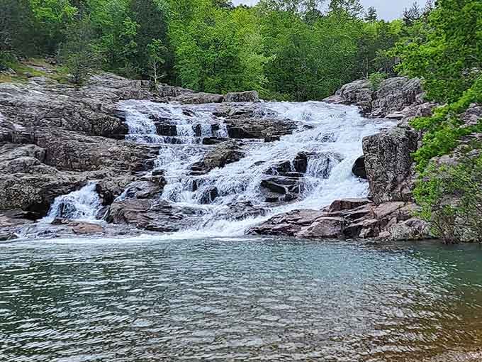 The cascading waters of Rocky Falls tumble over ancient rhyolite rock into crystal-clear pools perfect for summer swimming adventures.