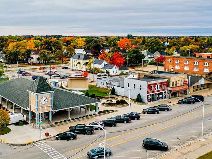 Fall colors transform this charming town square, where the clock tower building watches over streets lined with local businesses and autumn-painted trees.