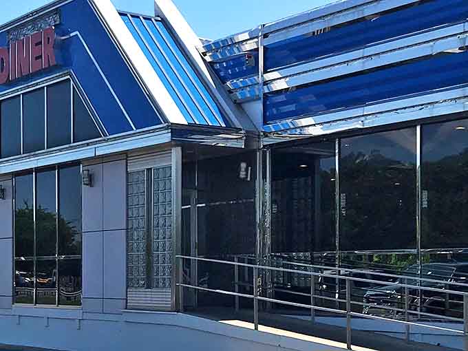 Sunlight reflects off the diner's sleek blue exterior, with wide windows giving it the feel of a perfect roadside oasis for hungry travelers.