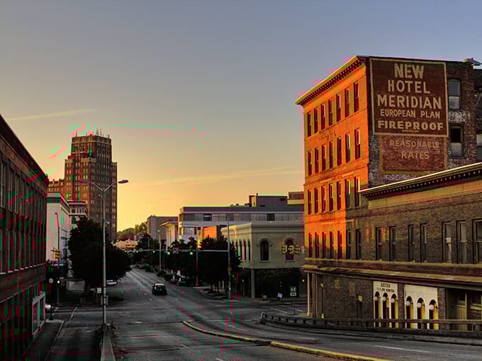 Downtown Meridian at sunset, where historic brick buildings catch the golden hour light like they're posing for a Mississippi postcard. The New Hotel Meridian sign stands as a charming reminder of the city's railroad heyday.