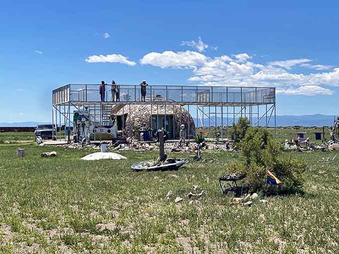 The healing garden sprawls around the platform like a cosmic welcome mat, decorated with trinkets from believers and skeptics alike.