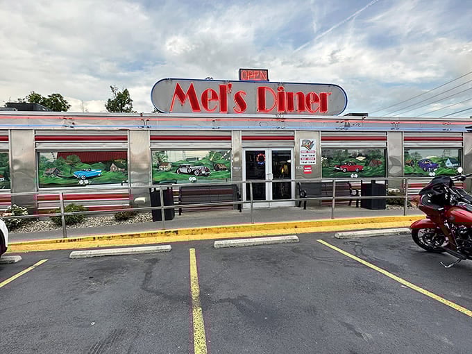 The gleaming silver exterior of Mel's Classic Diner stands defiant against moody Smoky Mountain skies, a chrome time capsule beckoning hungry travelers with its neon promise.