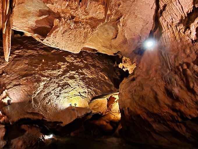 Stone curtains cascade from the ceiling like nature's own theater drapes, frozen mid-performance for millennia.