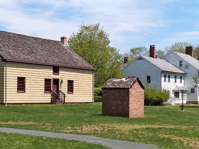 Historic structures nestled among towering trees create an authentic village where history actually happened, not Hollywood magic.