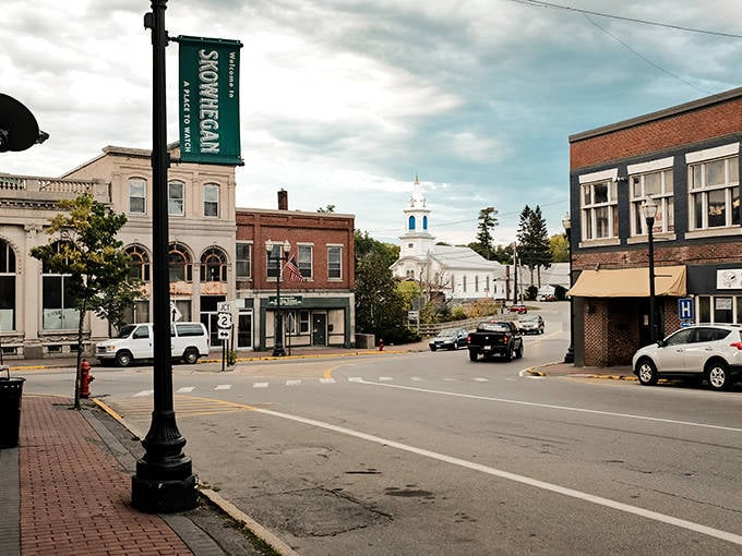 Downtown Skowhegan greets visitors with classic New England charm, where the white church steeple stands sentinel over brick buildings that have witnessed generations of Maine life.