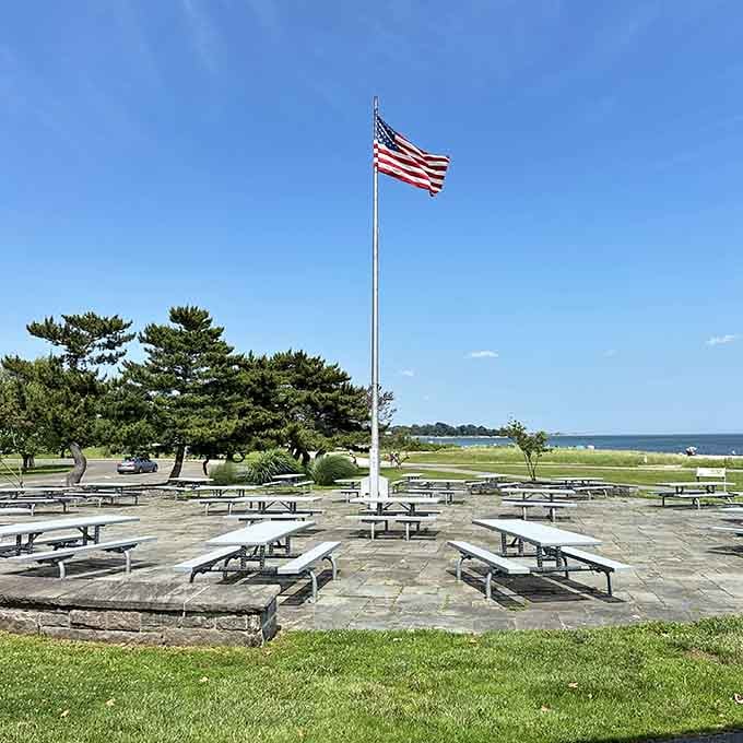 The picnic area stands ready for memory-making, with the American flag keeping watch over Long Island Sound. Patriotism with a view!