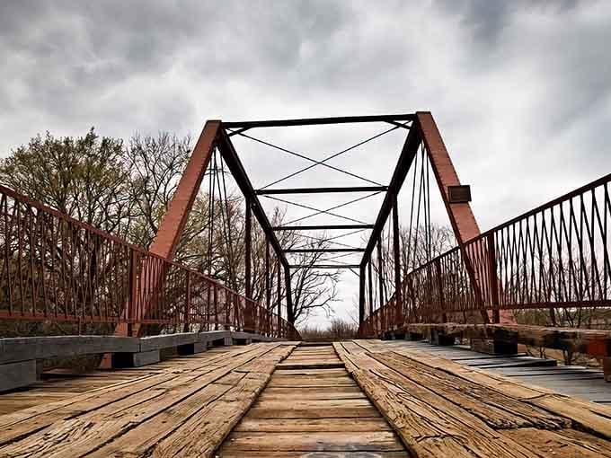 That rusty red iron against bare winter branches creates a scene straight out of a gothic novel.