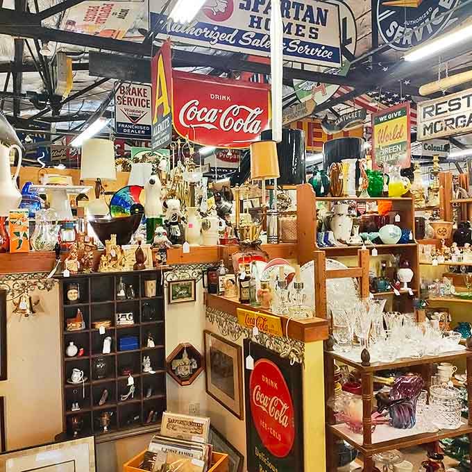 Vintage Coca-Cola signs hang above a wonderland of treasures, from glassware to collectibles, creating a nostalgic shopper's paradise.