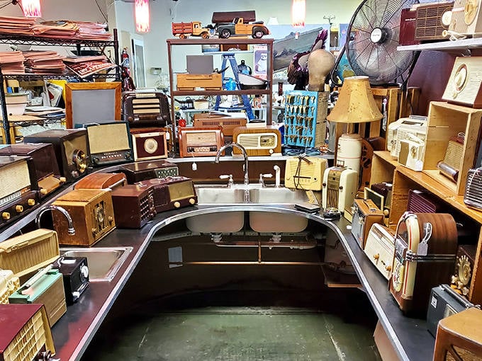 A vintage electronics wonderland where radios from every decade surround a stainless steel counter, like a time-traveling DJ booth waiting for its next spin.