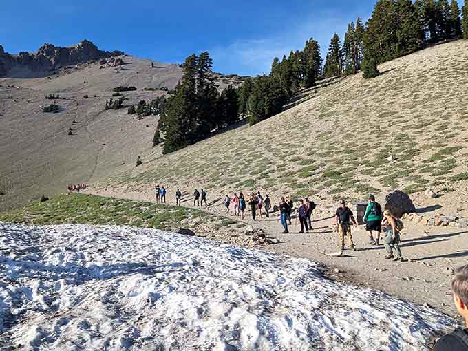 Early season hikers navigate snow patches like they're crossing a frozen river, adding extra adventure to an already exciting climb.