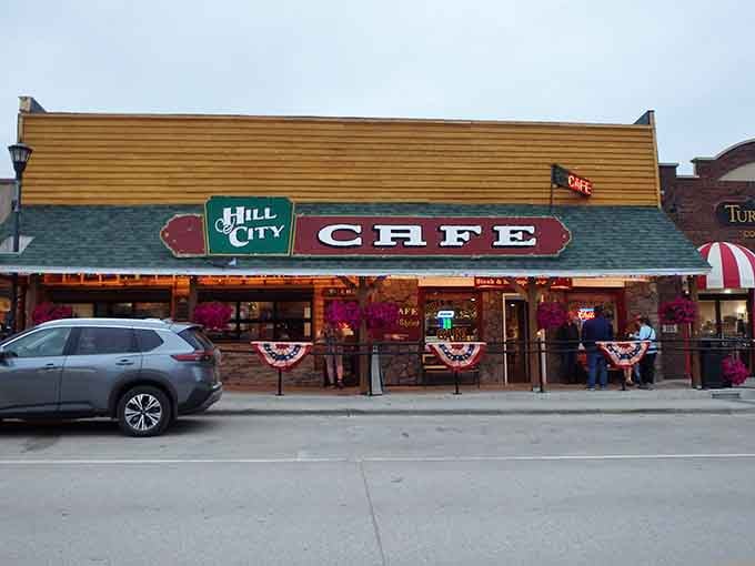 The iconic yellow and green storefront of Hill City Caf&eacute; stands proudly on Main Street, beckoning hungry travelers with its classic small-town charm.