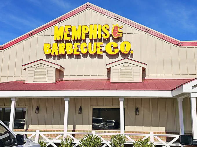 The iconic yellow sign against blue skies promises barbecue salvation ahead. Memphis Barbecue Company stands like a beacon for hungry souls seeking smoky perfection.
