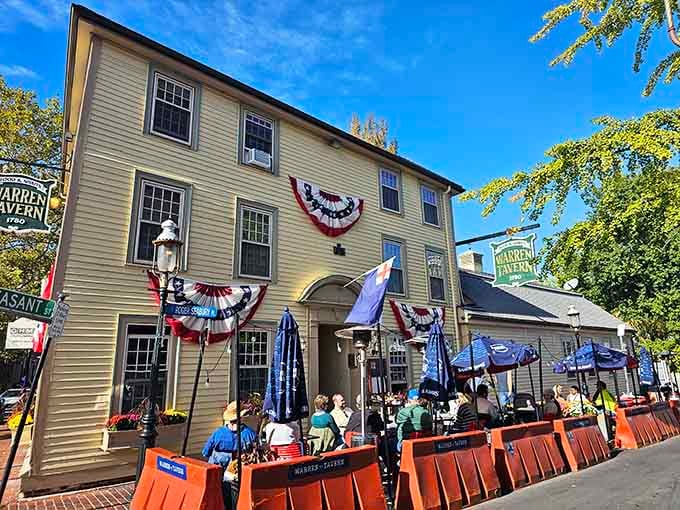 The yellow clapboard exterior of Warren Tavern stands as a colonial time capsule, complete with patriotic bunting and a welcoming patio for history buffs and foodies alike.