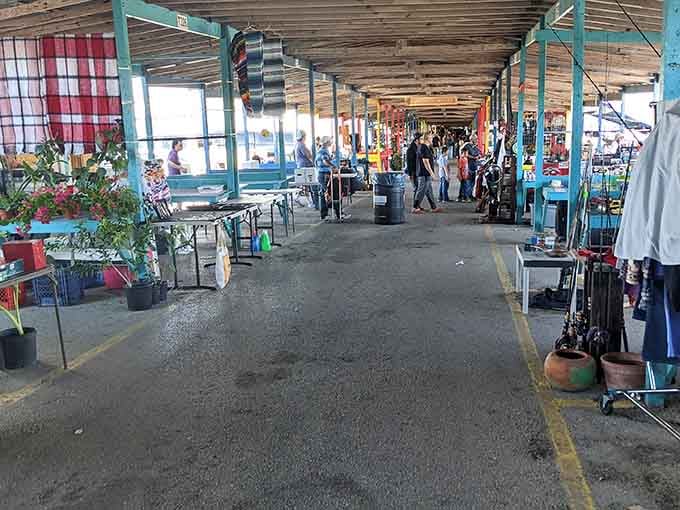 The covered pavilion stretches into the distance, lined with vendors and shoppers hunting for deals under those distinctive turquoise beams.