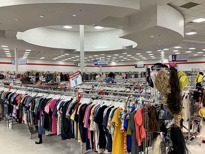 Rows of color-organized clothing stretch into the distance like a rainbow made entirely of second chances and savings.