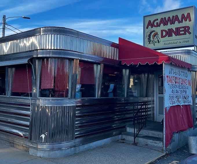The gleaming stainless steel exterior of Agawam Diner stands like a time capsule from the 1940s, complete with its iconic Native American logo and welcoming red awning.