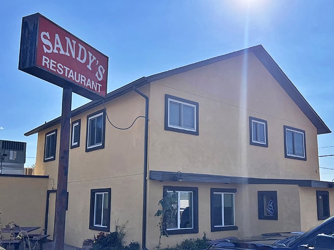 The iconic Sandy's sign stands tall against the Colorado blue sky, beckoning hungry travelers like a lighthouse for breakfast enthusiasts.