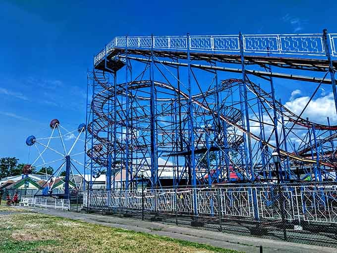 Engineering from a simpler era, the roller coaster's skeletal framework against a perfect blue sky promises the kind of stomach-dropping joy no smartphone app can replicate.