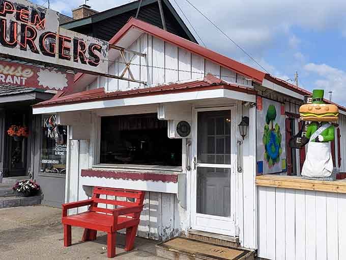The unassuming exterior of The Whitehouse Restaurant, where that red bench has heard more Michigan stories than a century-old oak tree.