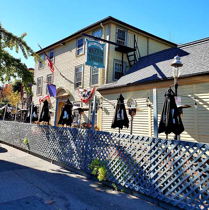 The yellow clapboard exterior of Warren Tavern stands as a colonial time capsule, complete with patriotic bunting and a welcoming patio for history buffs and foodies alike.