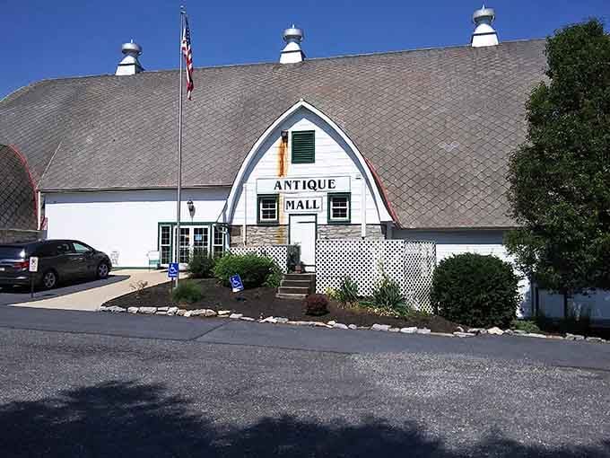 That charming white barn exterior is your first clue that something wonderfully overwhelming awaits inside those doors.