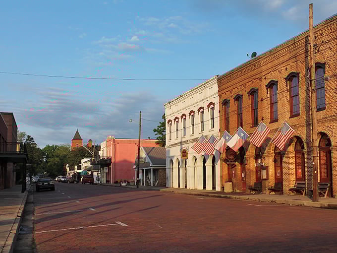 American flags flutter along Jefferson's main street, where preserved 19th-century storefronts create a living museum of Texas' riverport heyday.