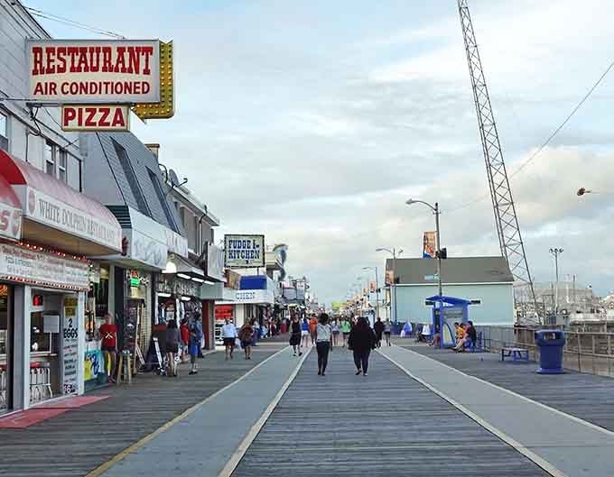 The boardwalk stretches endlessly, promising funnel cakes, questionable life choices, and memories you'll actually want to keep.