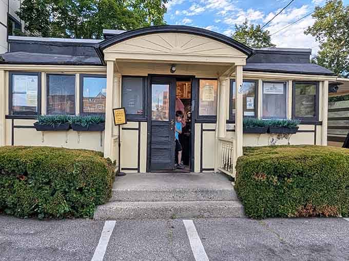 That cream-colored exterior with its charming peaked entrance isn't trying to impress anyone, and that's exactly why it does.