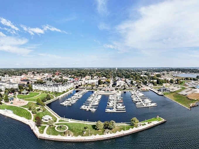 The marina sits like a perfectly organized jewelry box, boats gleaming in their slips like precious gems waiting to sail.