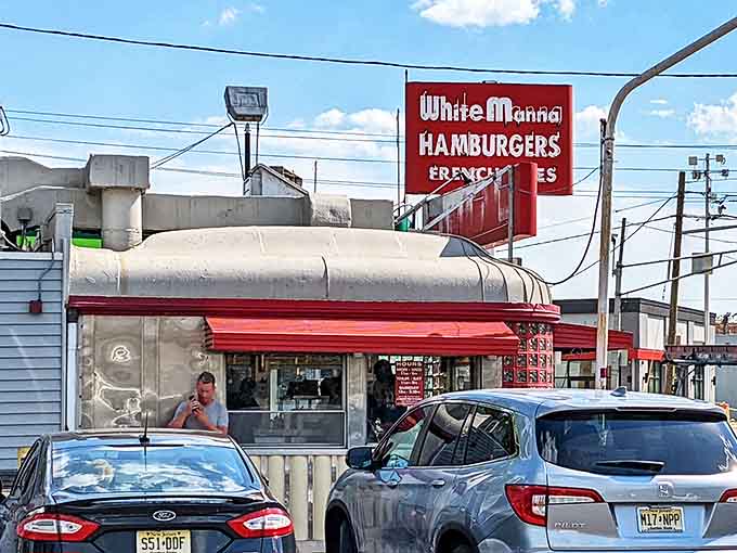 The iconic red and white signage of White Manna stands out against the sky like a beacon calling all burger enthusiasts home.