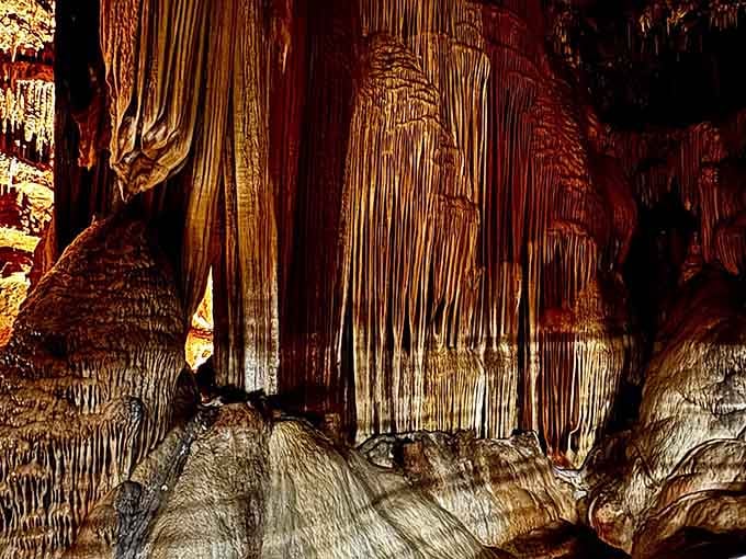 Majestic, rippling formations rise from the cave floor, capturing the raw beauty of nature's craftsmanship.