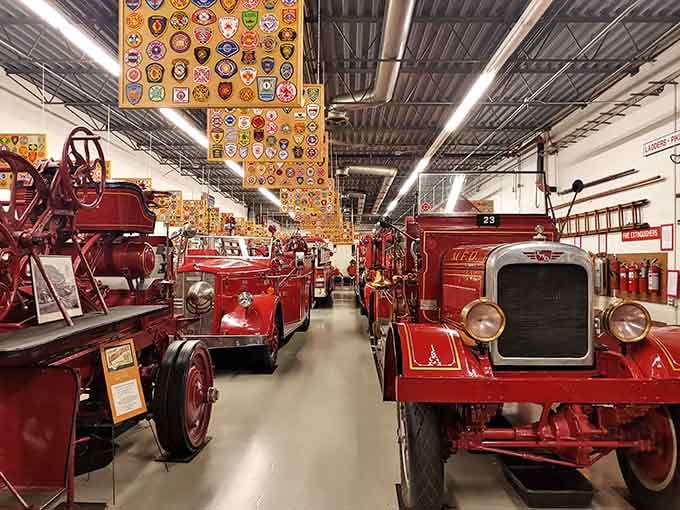 Rows of gleaming vintage fire engines stand at attention like a crimson parade frozen in time.