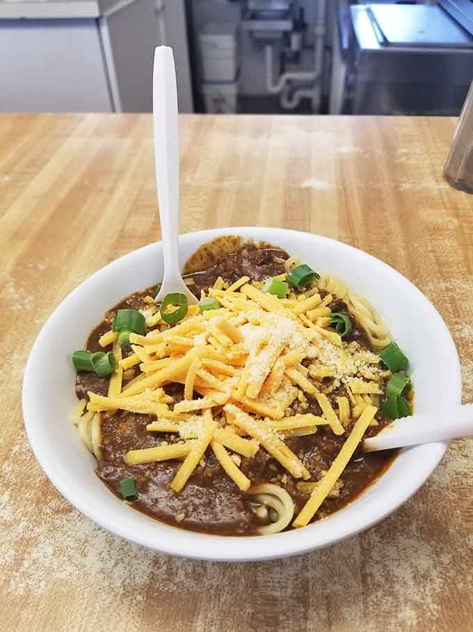 A bowl of chili topped with cheese and jalape&ntilde;os, ready to warm your soul or clear your sinuses, possibly both.