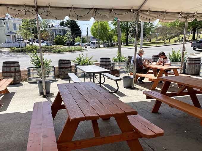 Picnic tables under a tent where strangers become friends united by smoke, sauce, and the pursuit of happiness.