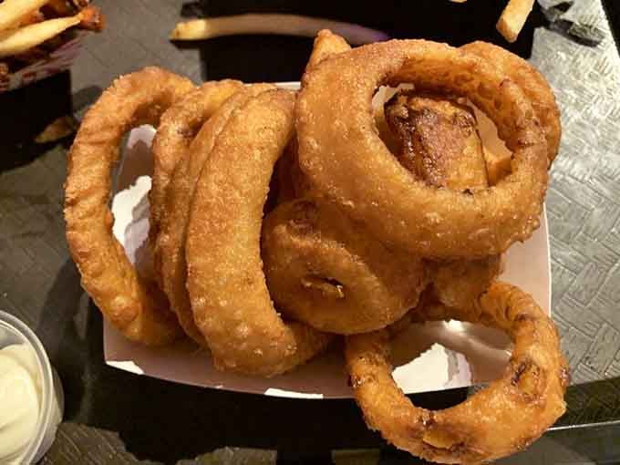 Golden, crispy onion rings stacked like edible architecture, ready to disappear faster than your New Year's resolutions.