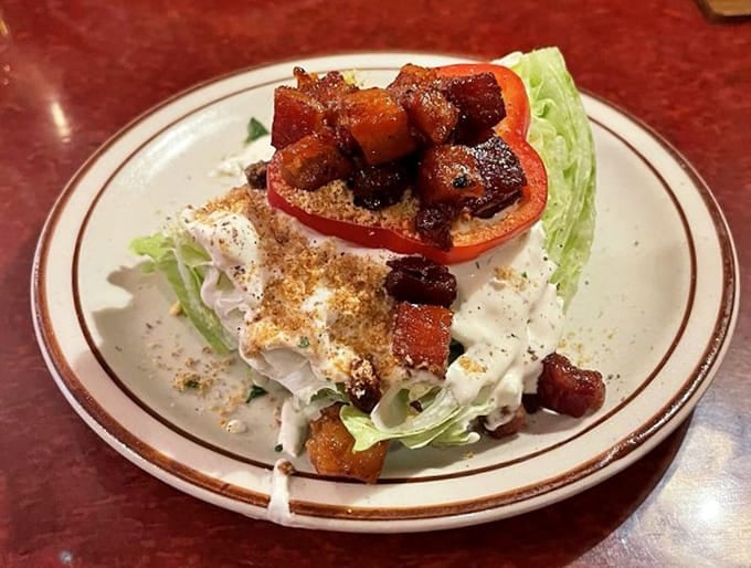 A wedge salad crowned with candied bacon, turning simple greens into something worth celebrating with genuine enthusiasm and appetite.