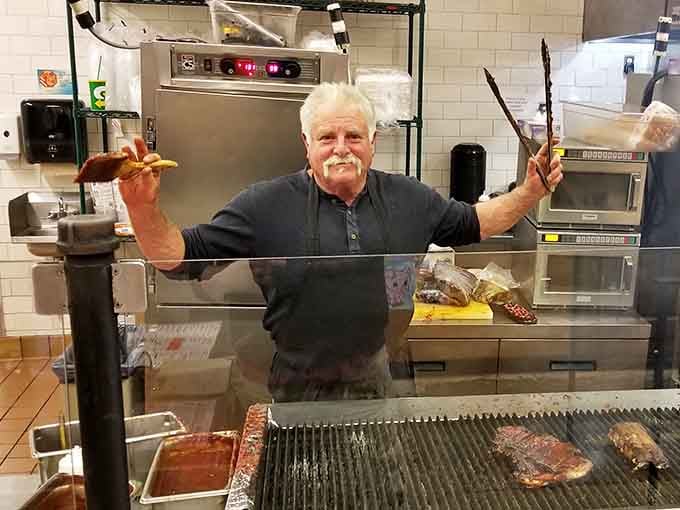 The pitmaster at work, wielding those tongs like a conductor leading a delicious, smoky symphony of flavors.