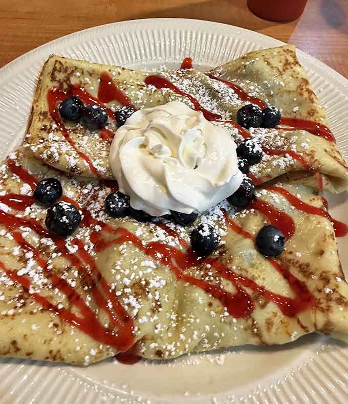 Crepes dressed up with blueberries and drizzled sauces, proving that thin pancakes can absolutely steal the show from their fluffier cousins.